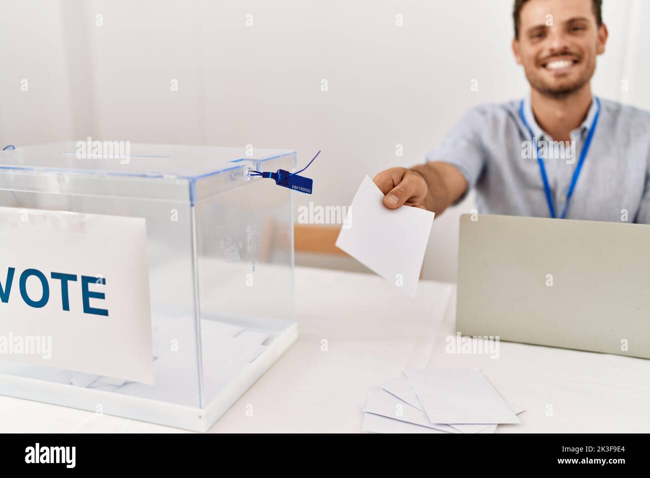 Young hispanic man smiling confident holding vote working at electoral ...