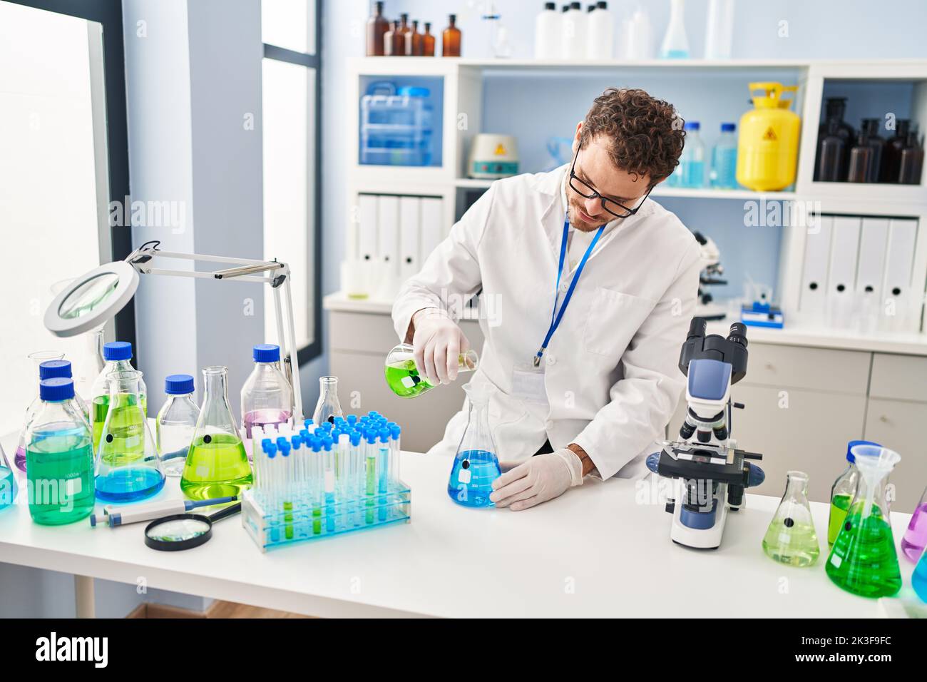 Young hispanic man scientist measuring liquid at laboratory Stock Photo ...