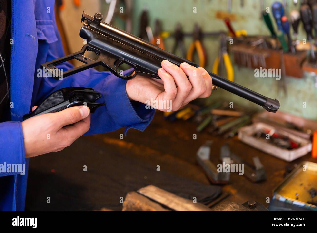 Dismantling and repair of combat pistol in weapons workshop Stock Photo ...