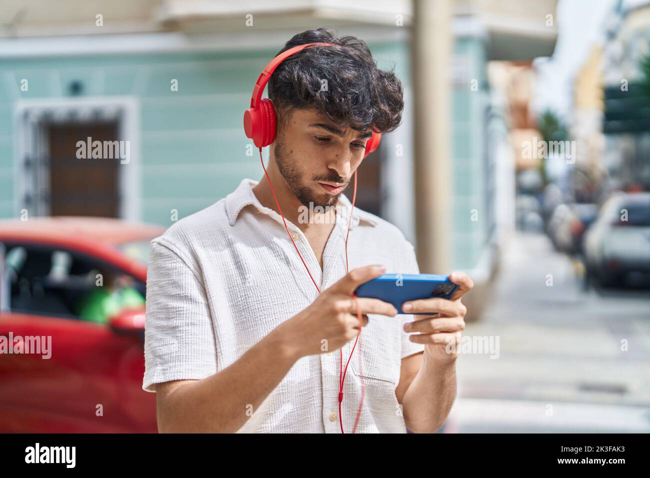 Young arab man playing video game at street Stock Photo - Alamy