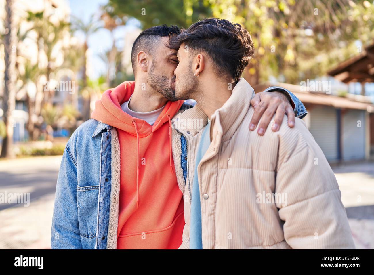 Two man couple hugging each other and kissing at park Stock Photo - Alamy