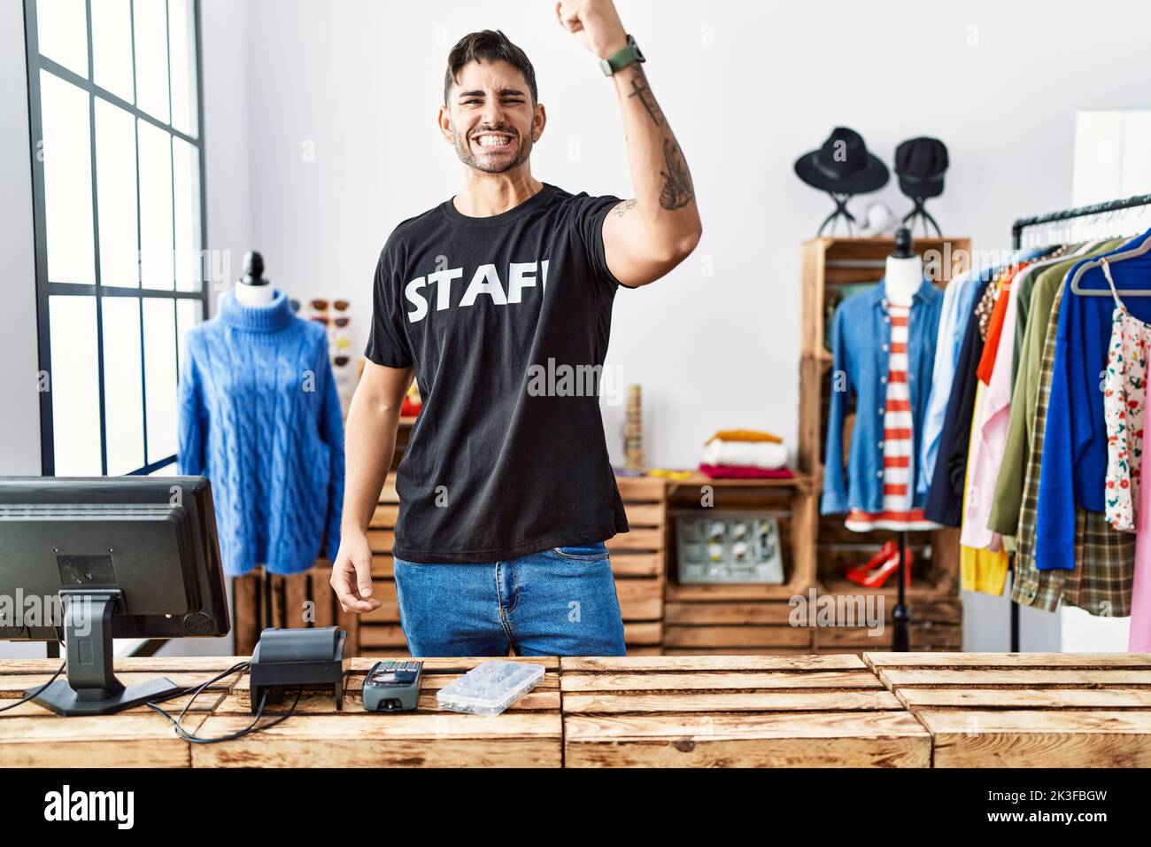 Young hispanic man working at retail boutique angry and mad raising ...