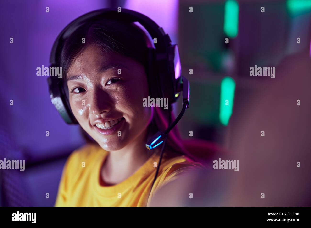 Chinese woman streamer using headset make selfie by camera at gaming ...