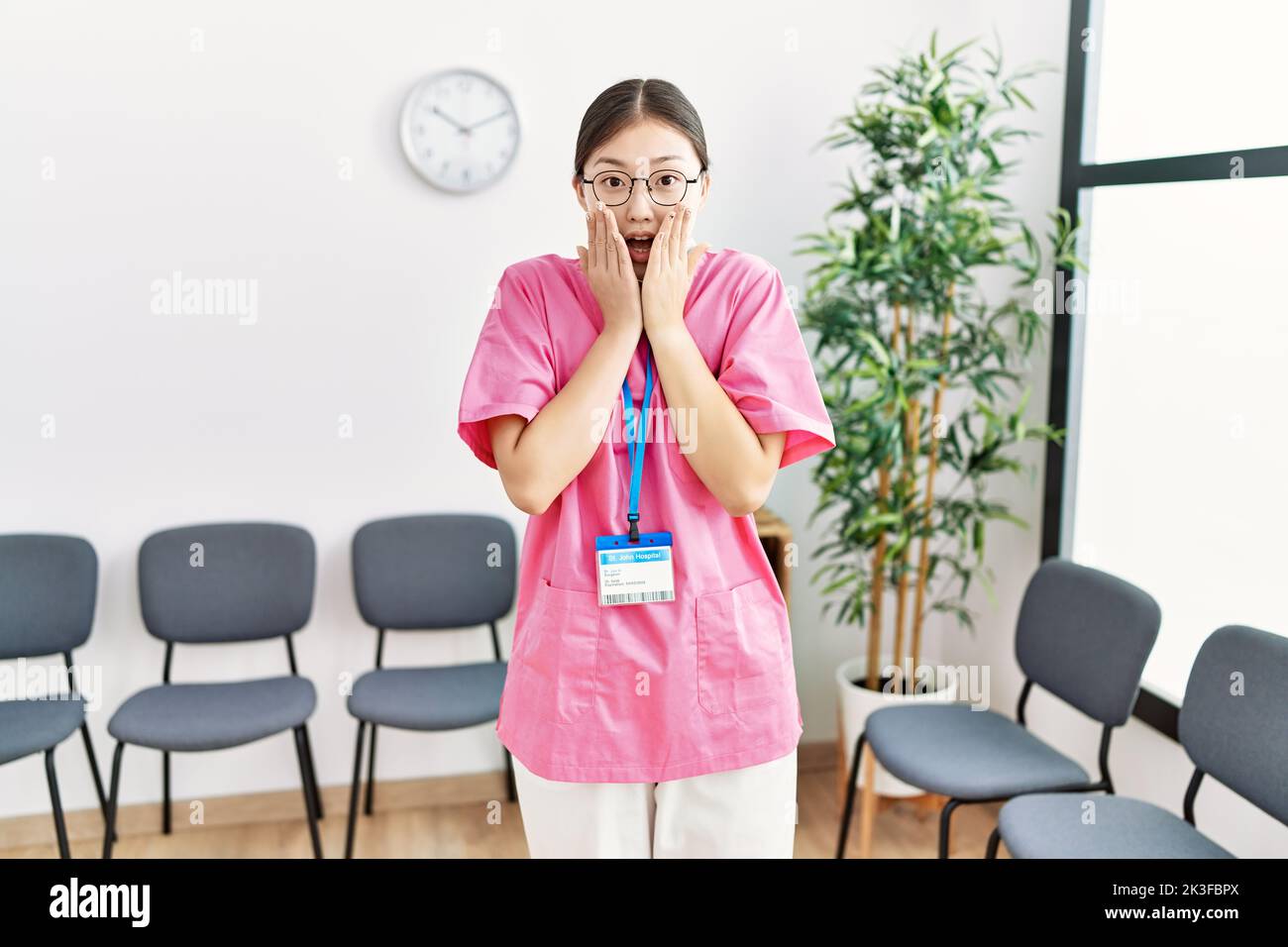 Young asian nurse woman at medical waiting room afraid and shocked ...