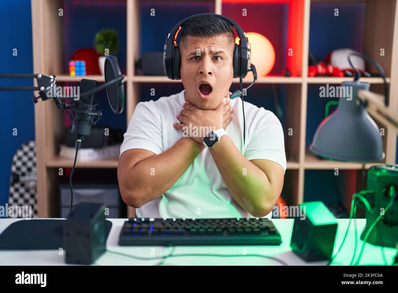 Young hispanic man playing video games shouting suffocate because ...
