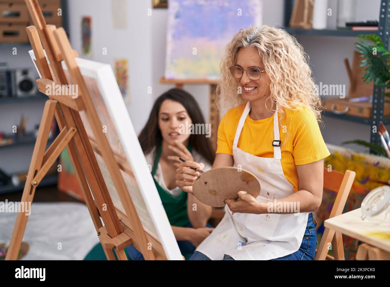 Two women artists smiling confident drawing at art studio Stock Photo ...