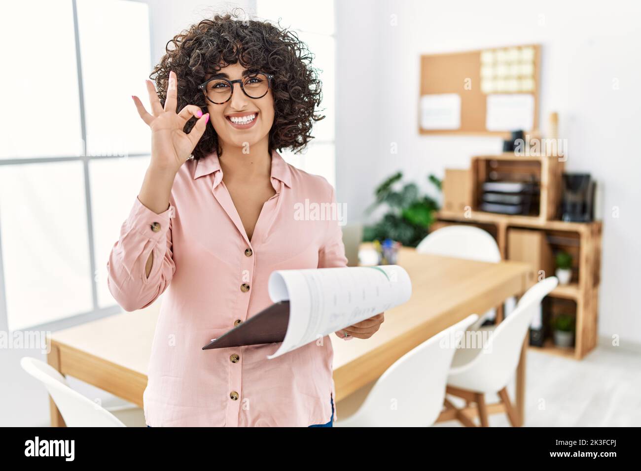 Young middle eastern woman wearing business style at office smiling ...