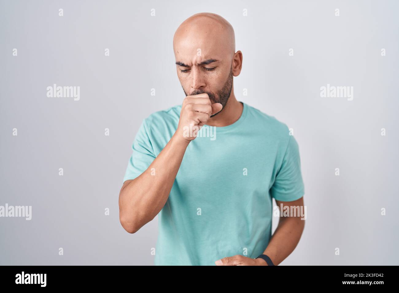 Middle age bald man standing over white background feeling unwell and ...