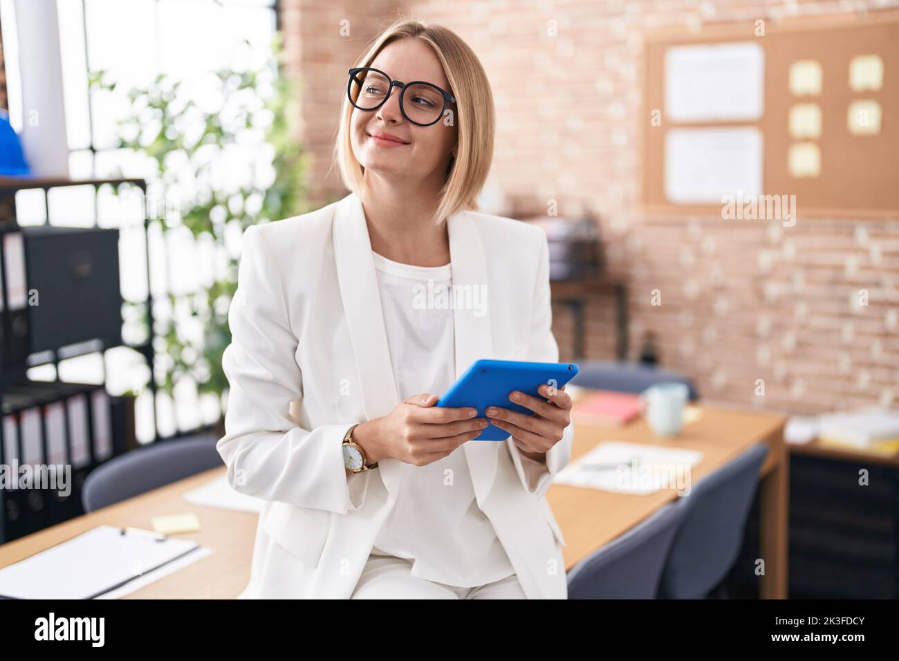Young caucasian woman working at the office wearing glasses smiling ...