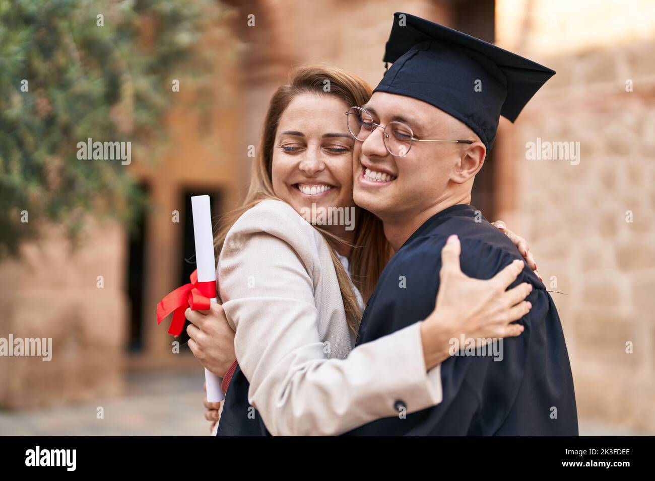 Man and woman mother and son hugging each other celebrating graduation ...