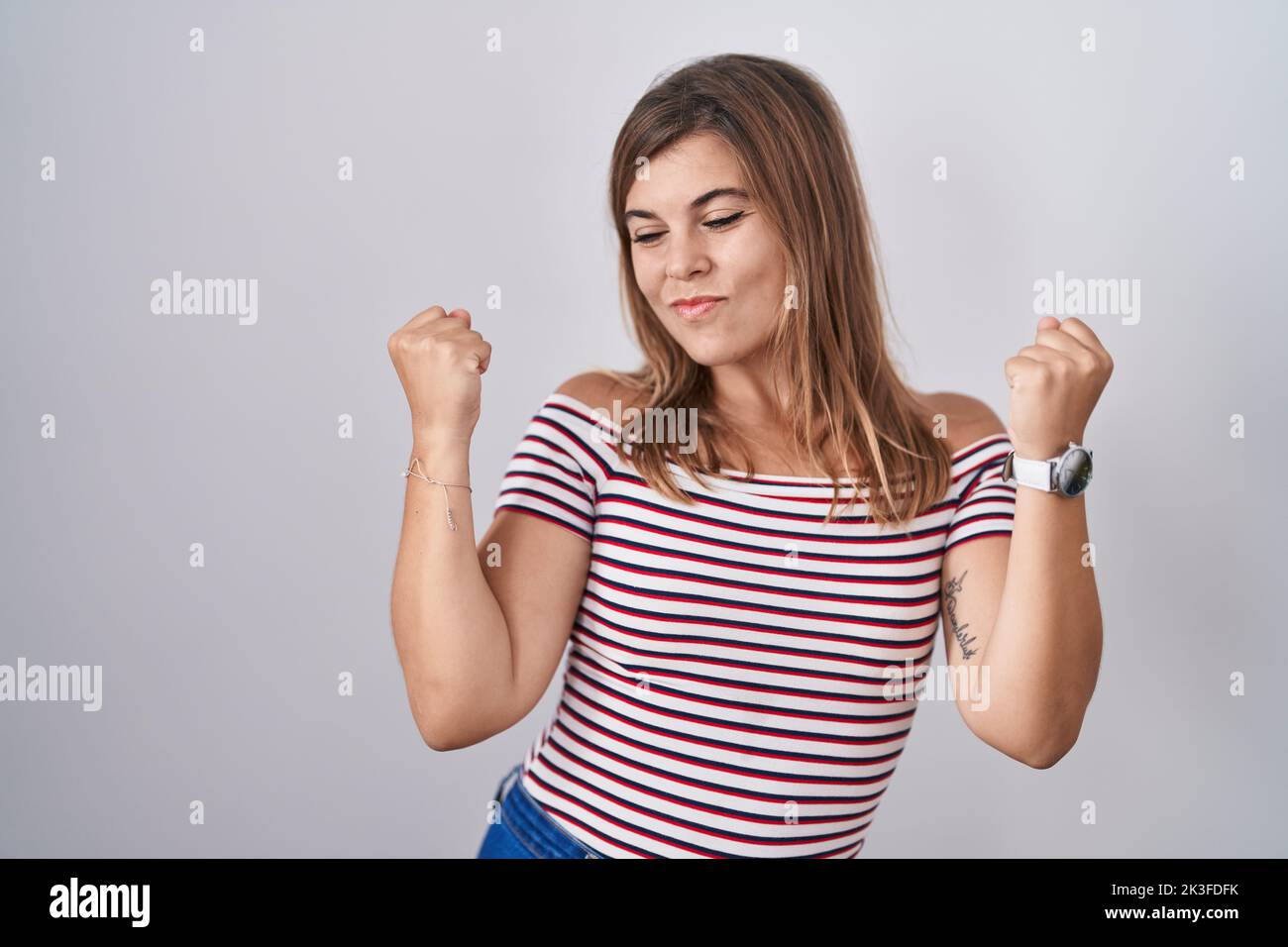 Young hispanic woman standing over isolated background celebrating ...