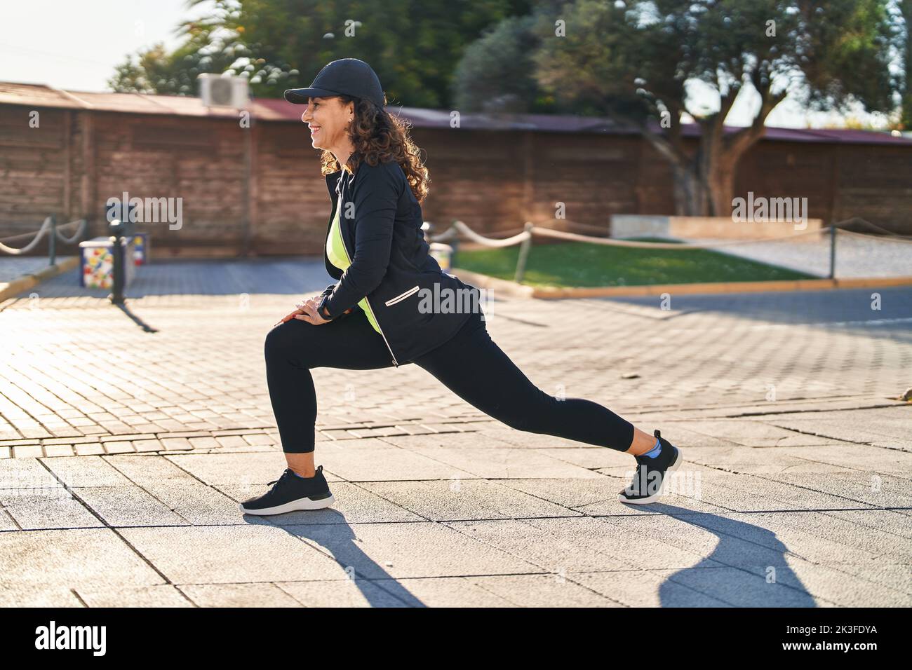 Middle age hispanic woman stretching legs outdoors Stock Photo - Alamy