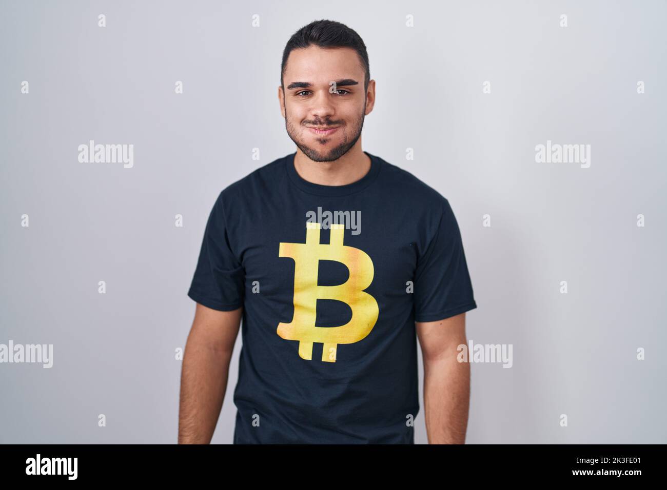 Young hispanic man wearing bitcoin t shirt puffing cheeks with funny ...