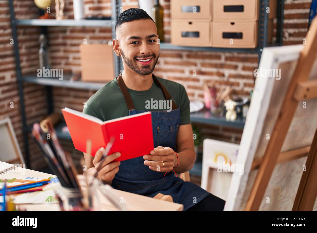 African american man artist smiling confident reading at art studio ...