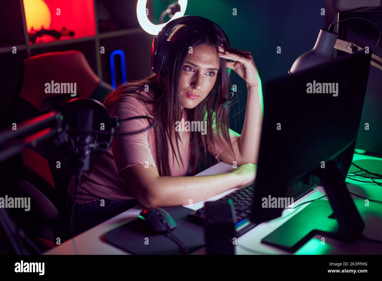 Young beautiful hispanic woman streamer stressed using computer at ...