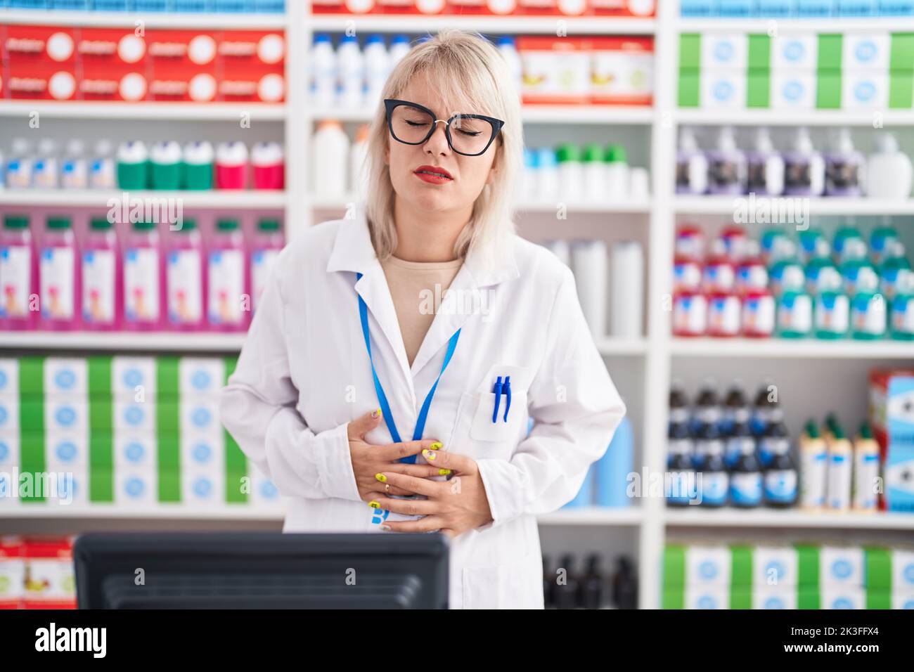 Young caucasian woman working at pharmacy drugstore with hand on ...