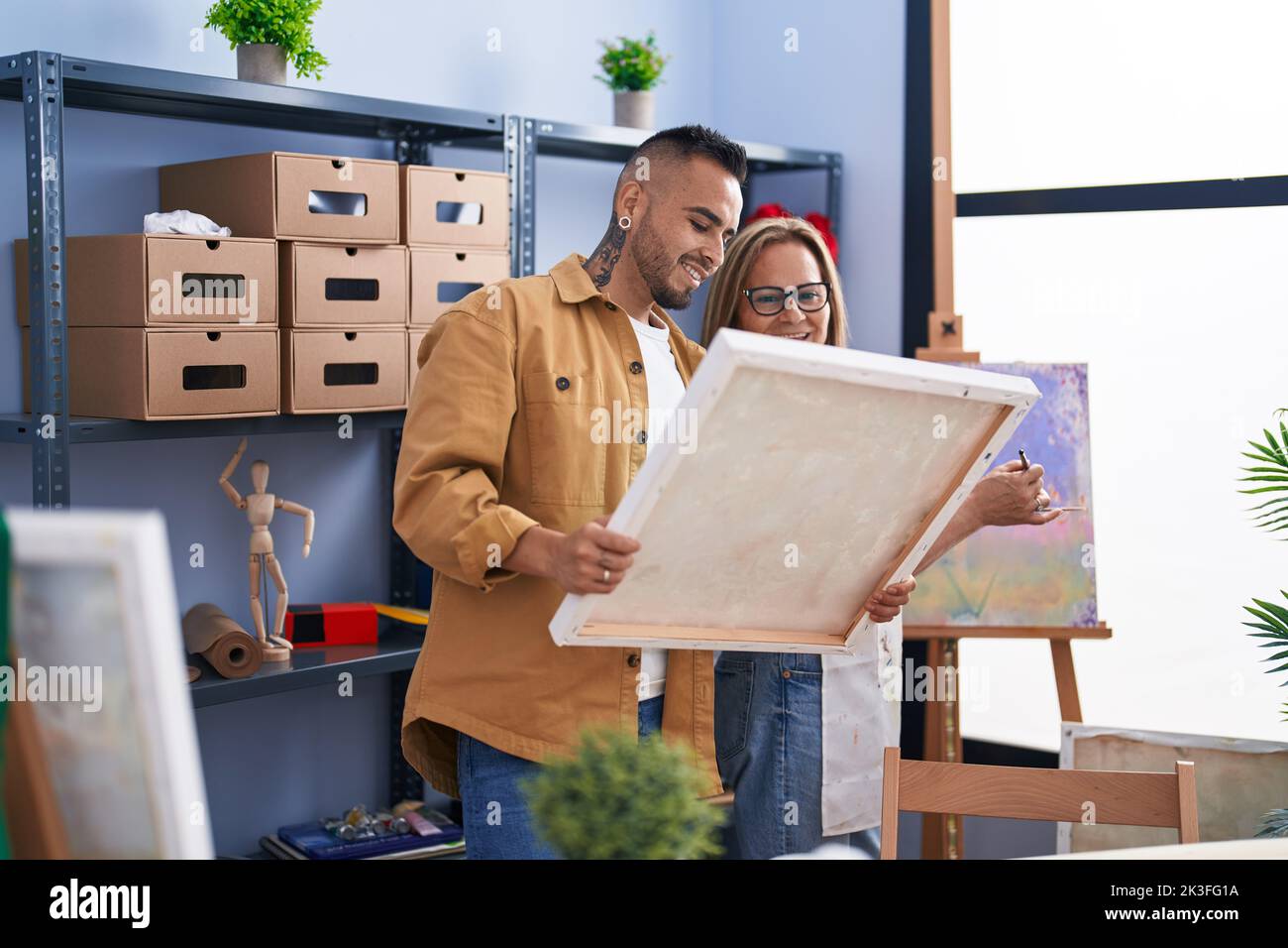 Man and woman artists looking draw standing at art studio Stock Photo ...