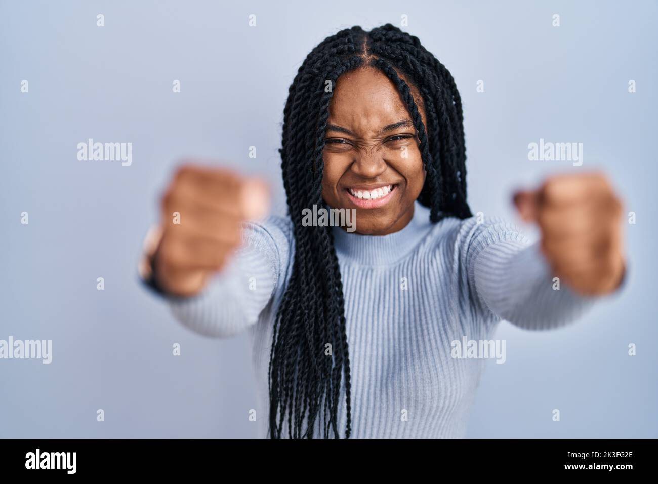 African american woman standing over blue background angry and mad ...
