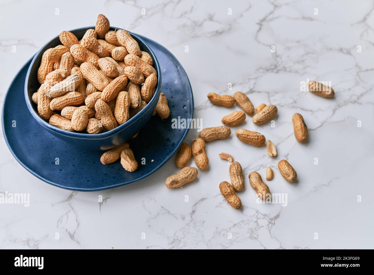 Image of bunch of peanuts in a bowl on a marble table Stock Photo - Alamy