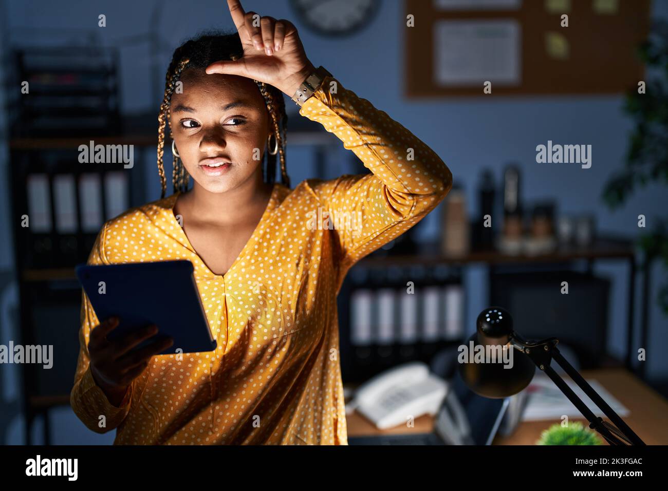 African american woman with braids working at the office at night with ...
