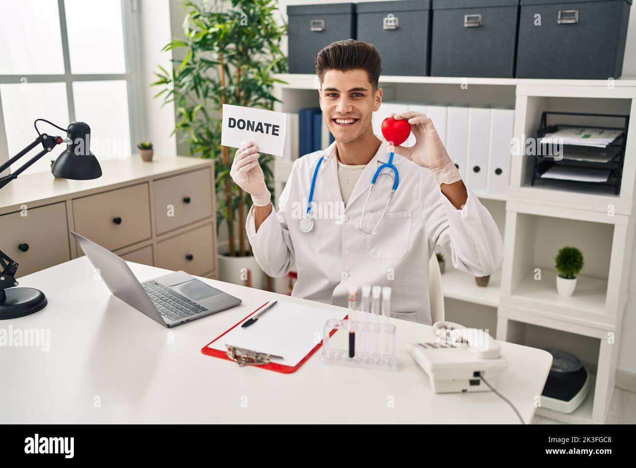 Young hispanic doctor man supporting organs donations smiling with a ...
