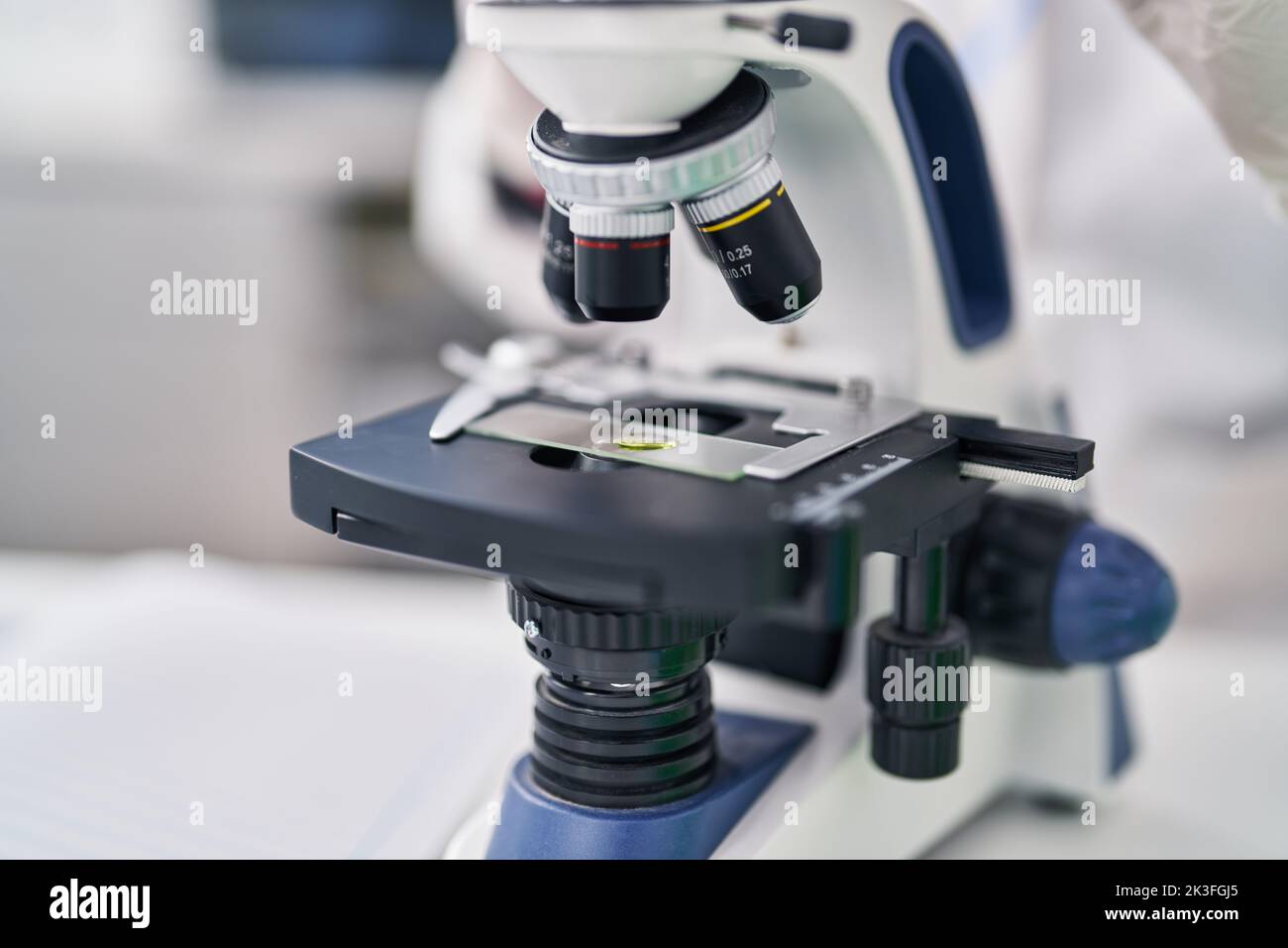Young hispanic man scientist using microscope working at laboratory ...