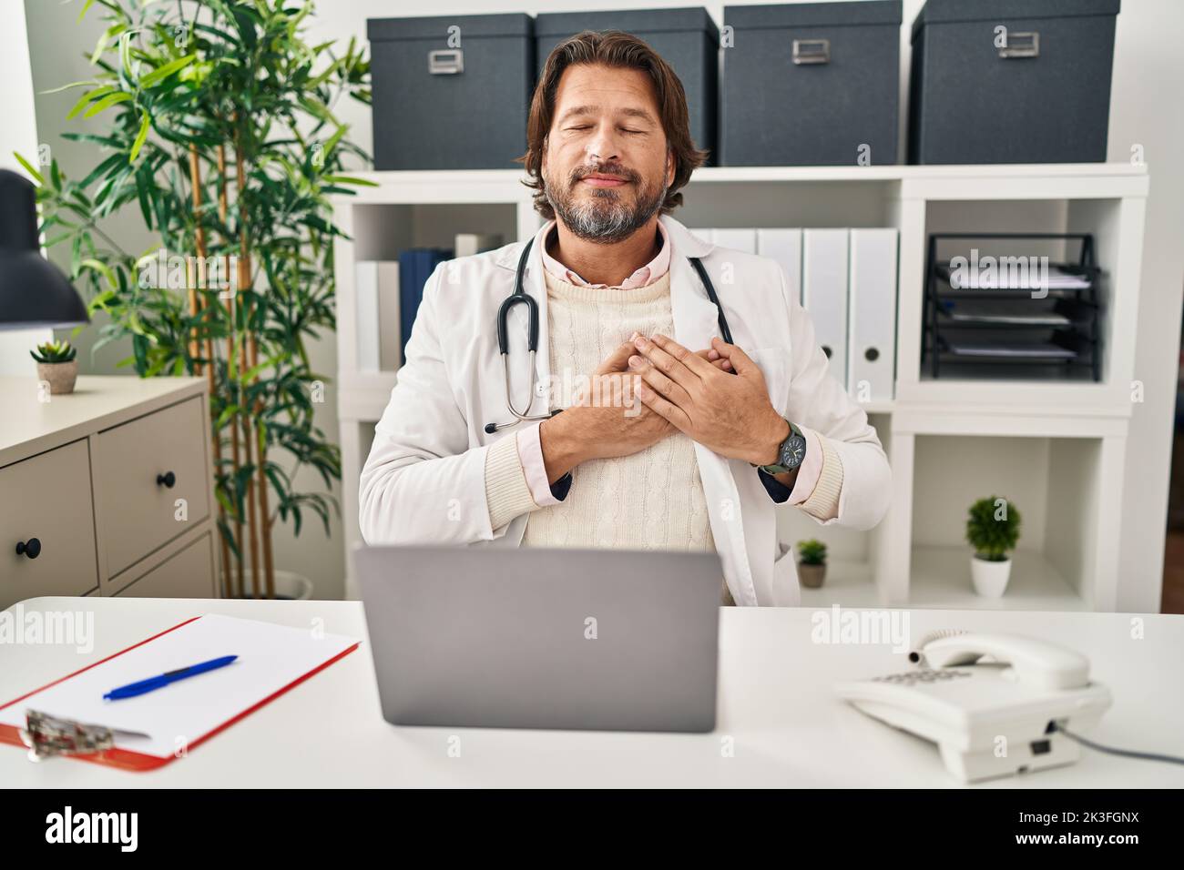 Handsome middle age doctor man working at the clinic smiling with hands ...