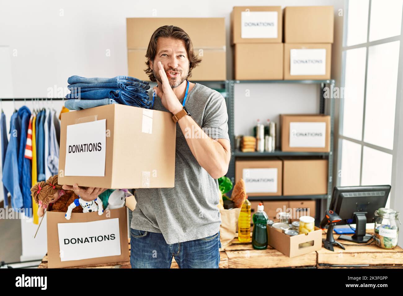 Handsome middle age man holding donations box for charity at volunteer ...