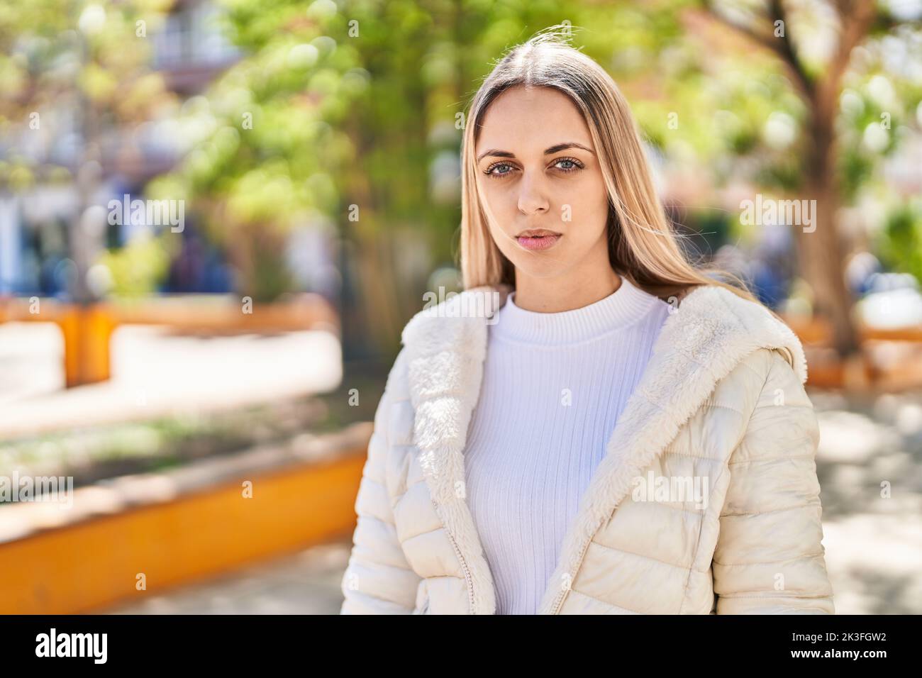 Young woman with relaxed expression standing at park Stock Photo - Alamy