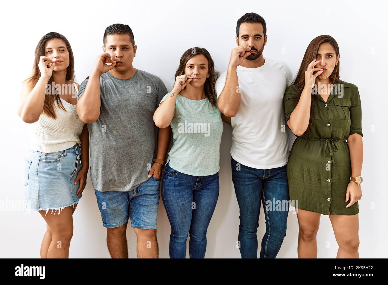Group of young hispanic friends standing together over isolated ...