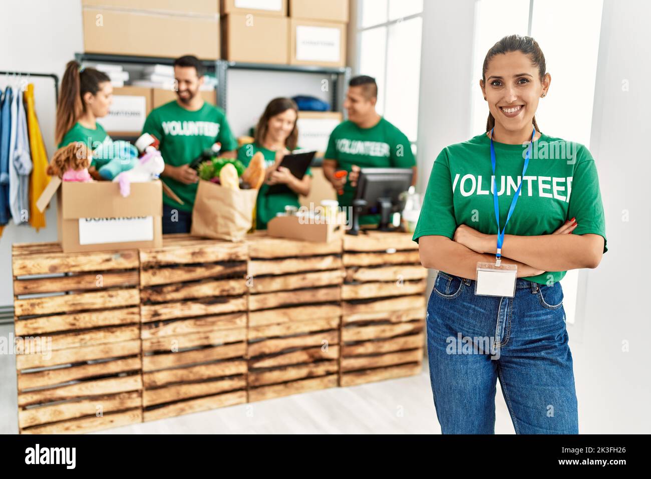 Group of young volunteers working at charity center. Woman smiling ...