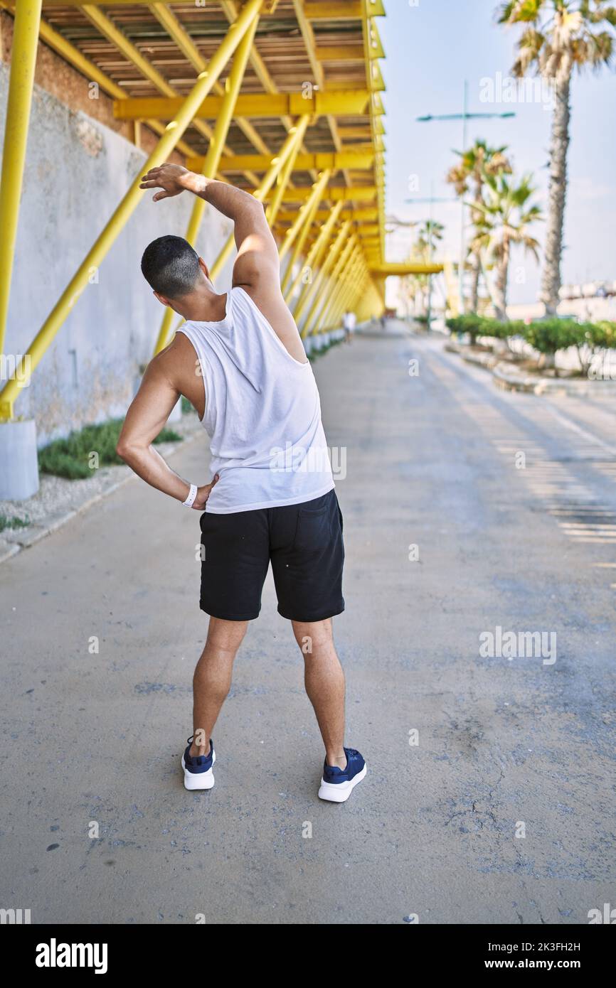 Hispanic man stretching after working out outdoors on a sunny day Stock ...
