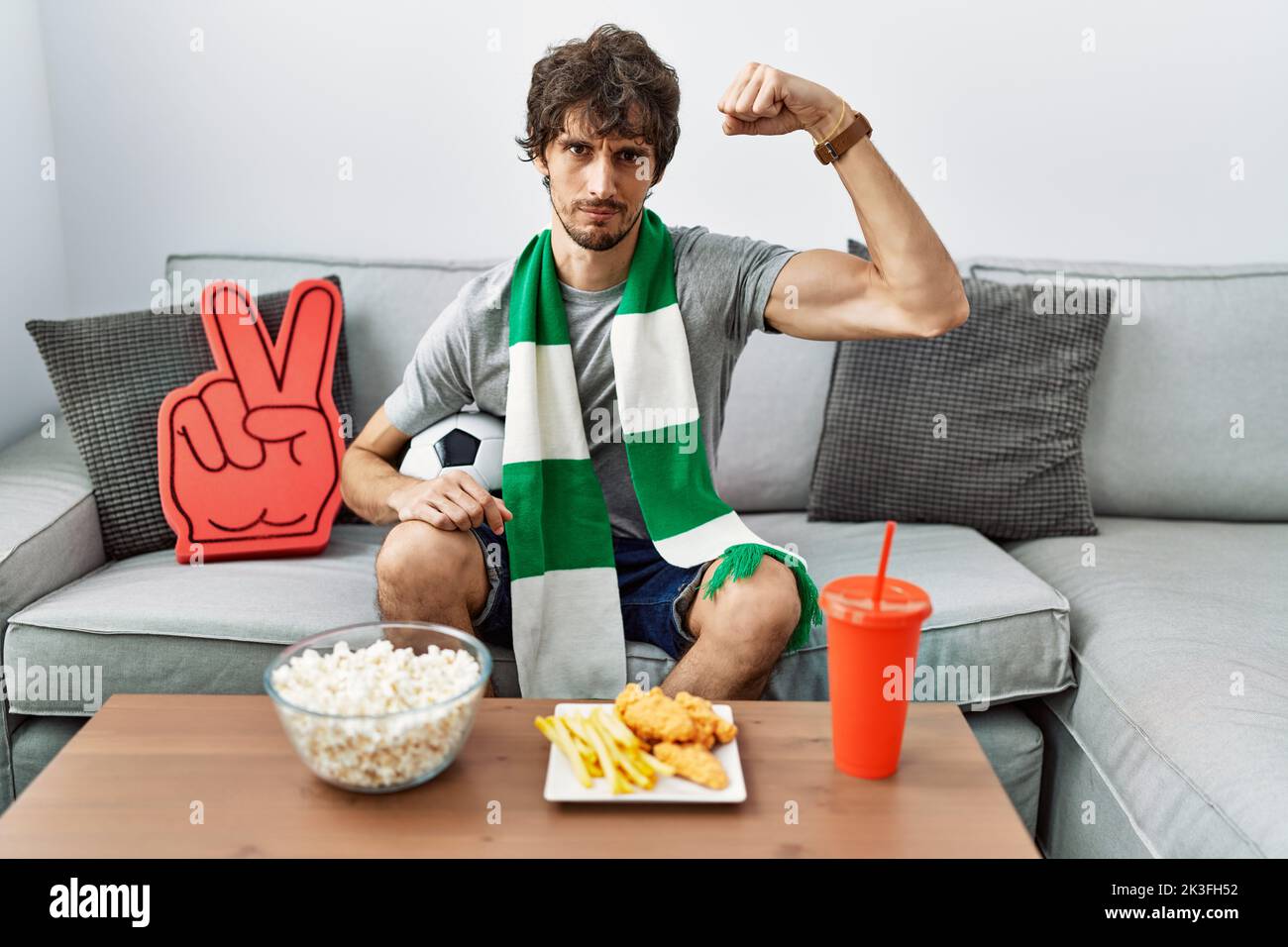 Young hispanic man football hooligan cheering game at home strong ...