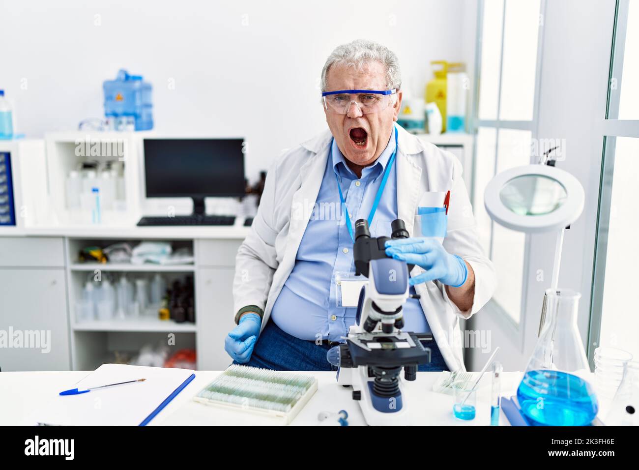 Senior caucasian man working at scientist laboratory angry and mad ...
