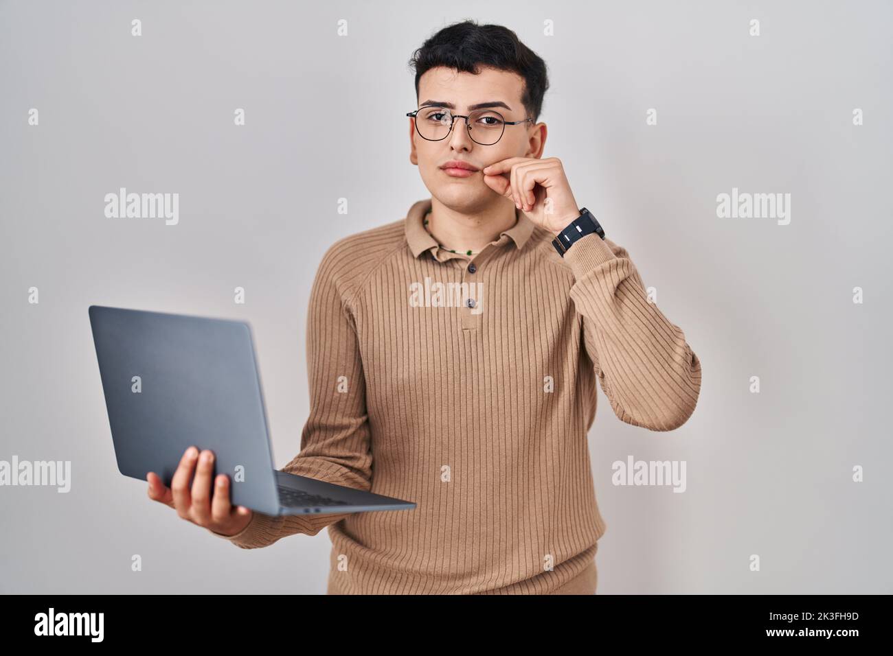 Non binary person using computer laptop mouth and lips shut as zip with ...