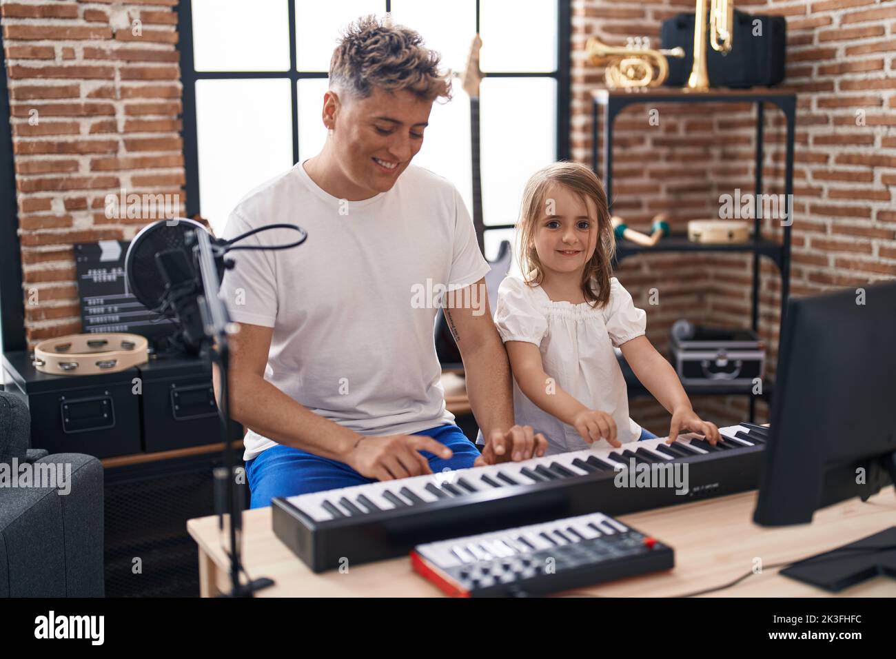 Father and daughter playing piano keyboard at music studio Stock Photo ...