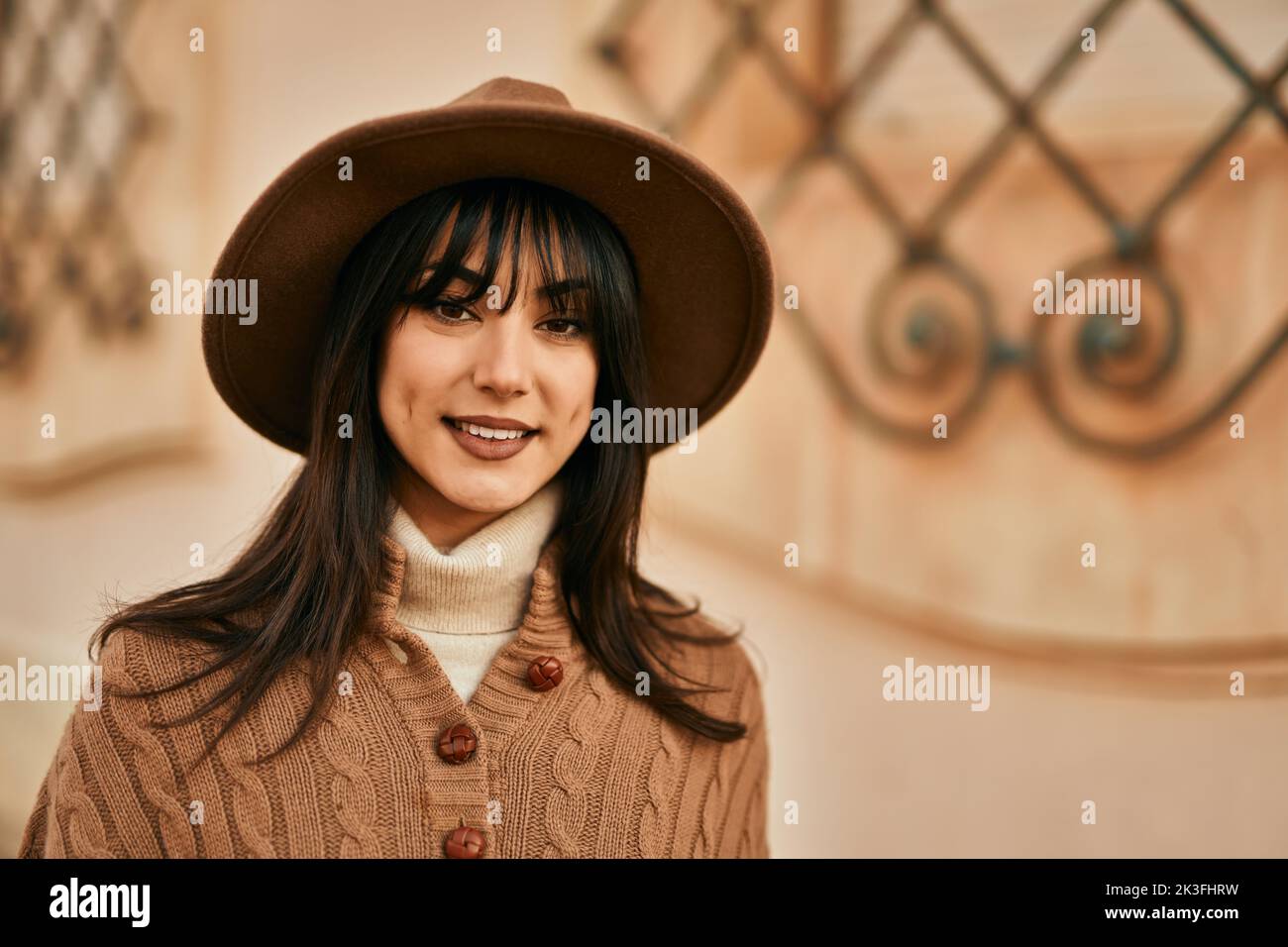 Brunette woman wearing winter hat smiling outdoors at the city Stock ...