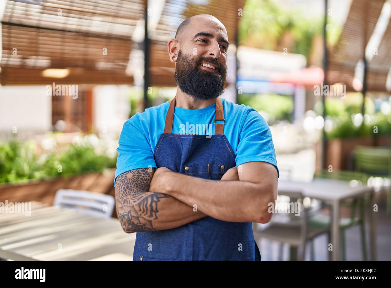 Young bald man waiter smiling confident standing with arms crossed ...