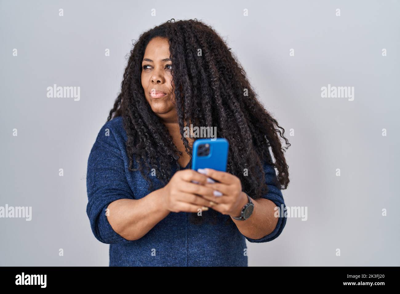 Plus size hispanic woman using smartphone typing message smiling ...