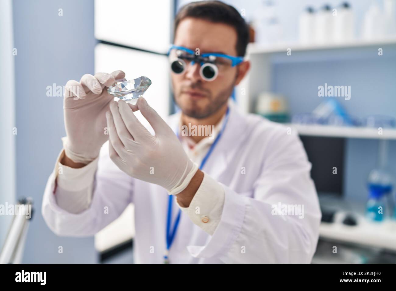 Young hispanic man scientist looking diamond by magnifying glasses at ...