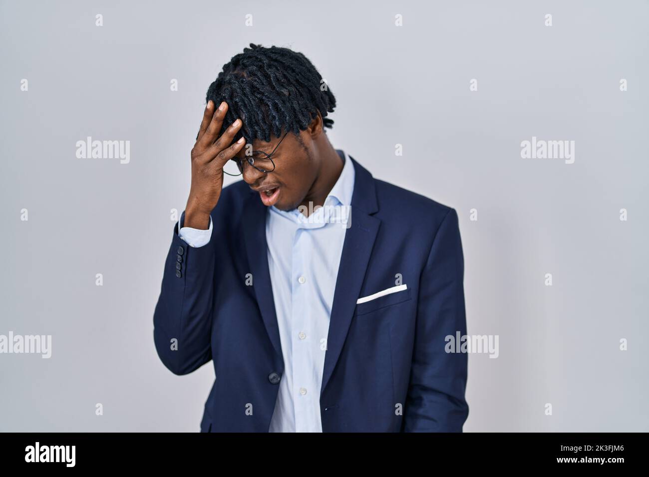 Young african man with dreadlocks wearing business jacket over white ...