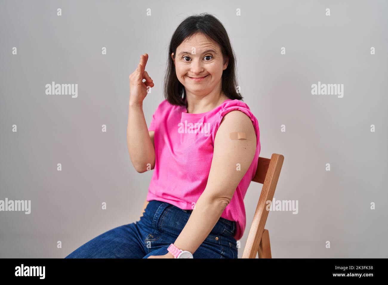 Woman with down syndrome wearing band aid for vaccine injection doing ...