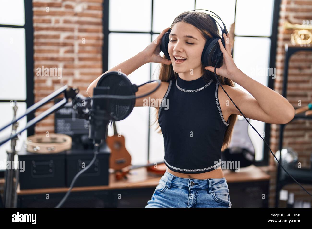 Adorable girl artist singing song at music studio Stock Photo - Alamy