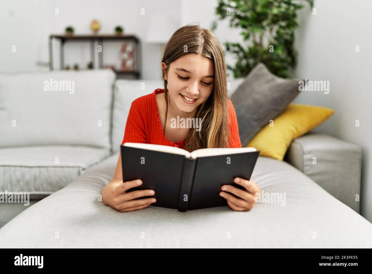 Adorable girl smiling confident reading book at home Stock Photo - Alamy