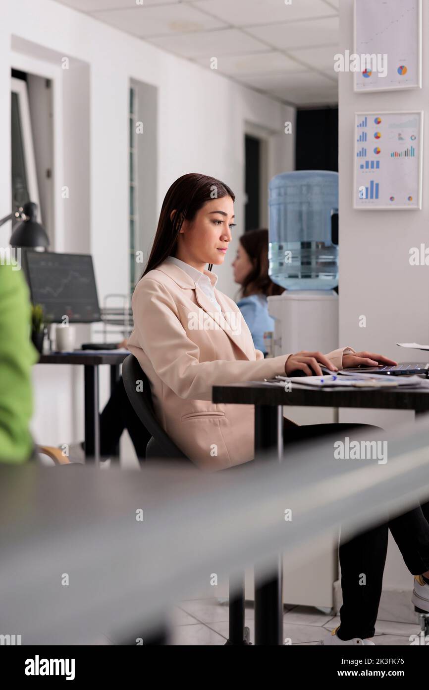 Young asian woman working on laptop in business office, company manager ...
