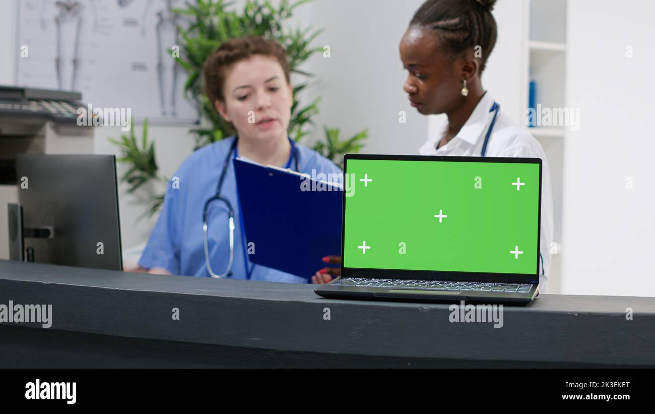 Laptop with greenscreen display on hospital reception counter used by ...