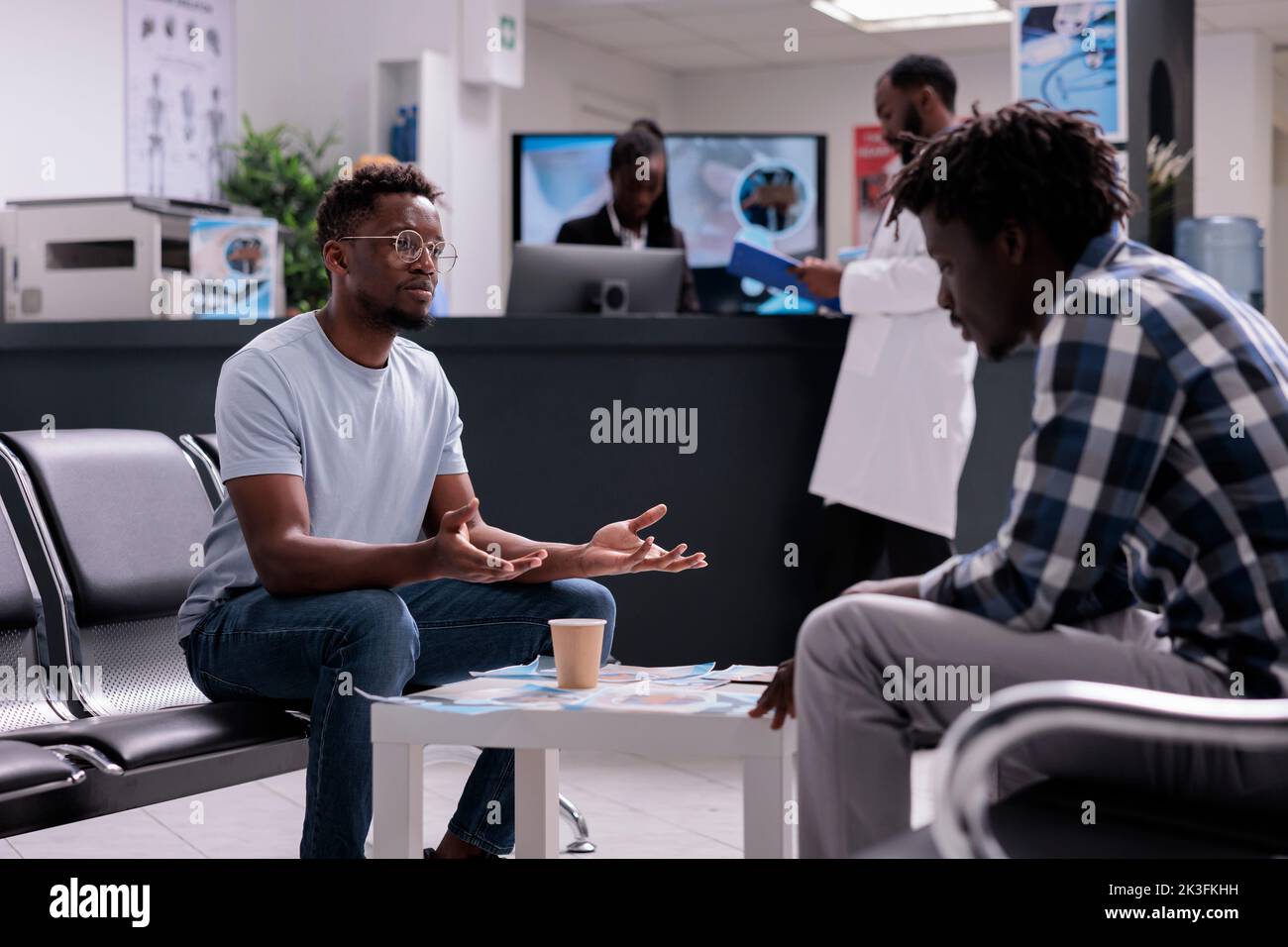 Group of patients talking in waiting area at hospital lobby before ...