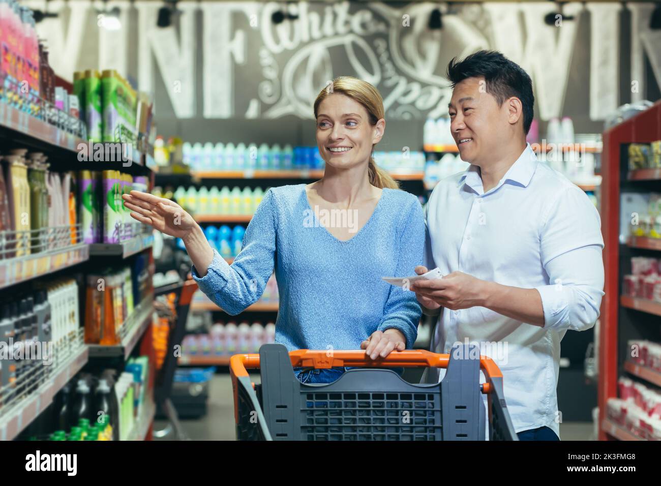 A young international couple, a woman and an Asian man walk between ...