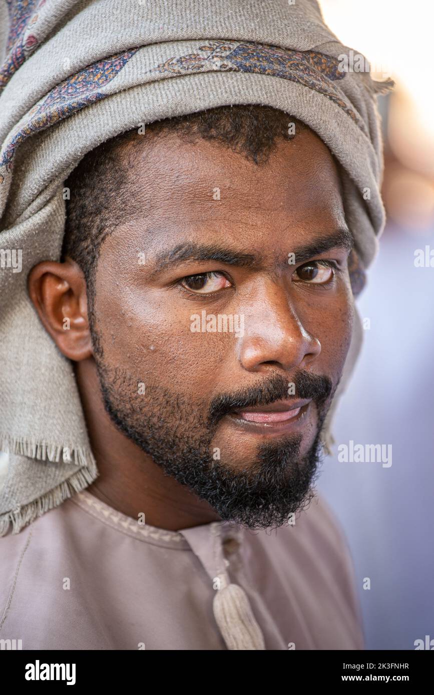 Portrait of a young man with white turban at friday morning cattle ...