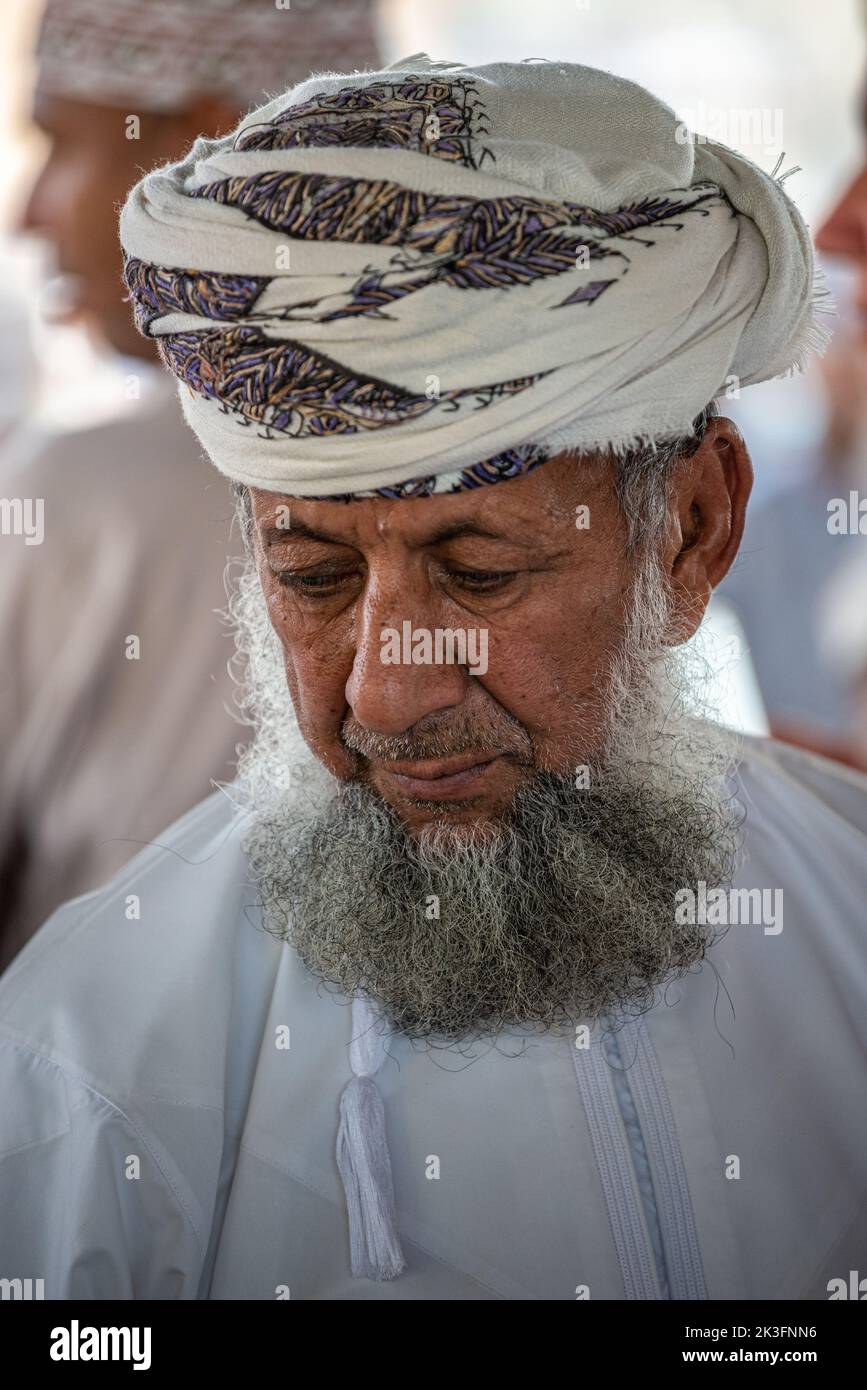 Adult bearded man in traditional wear at the friday morning cattle ...